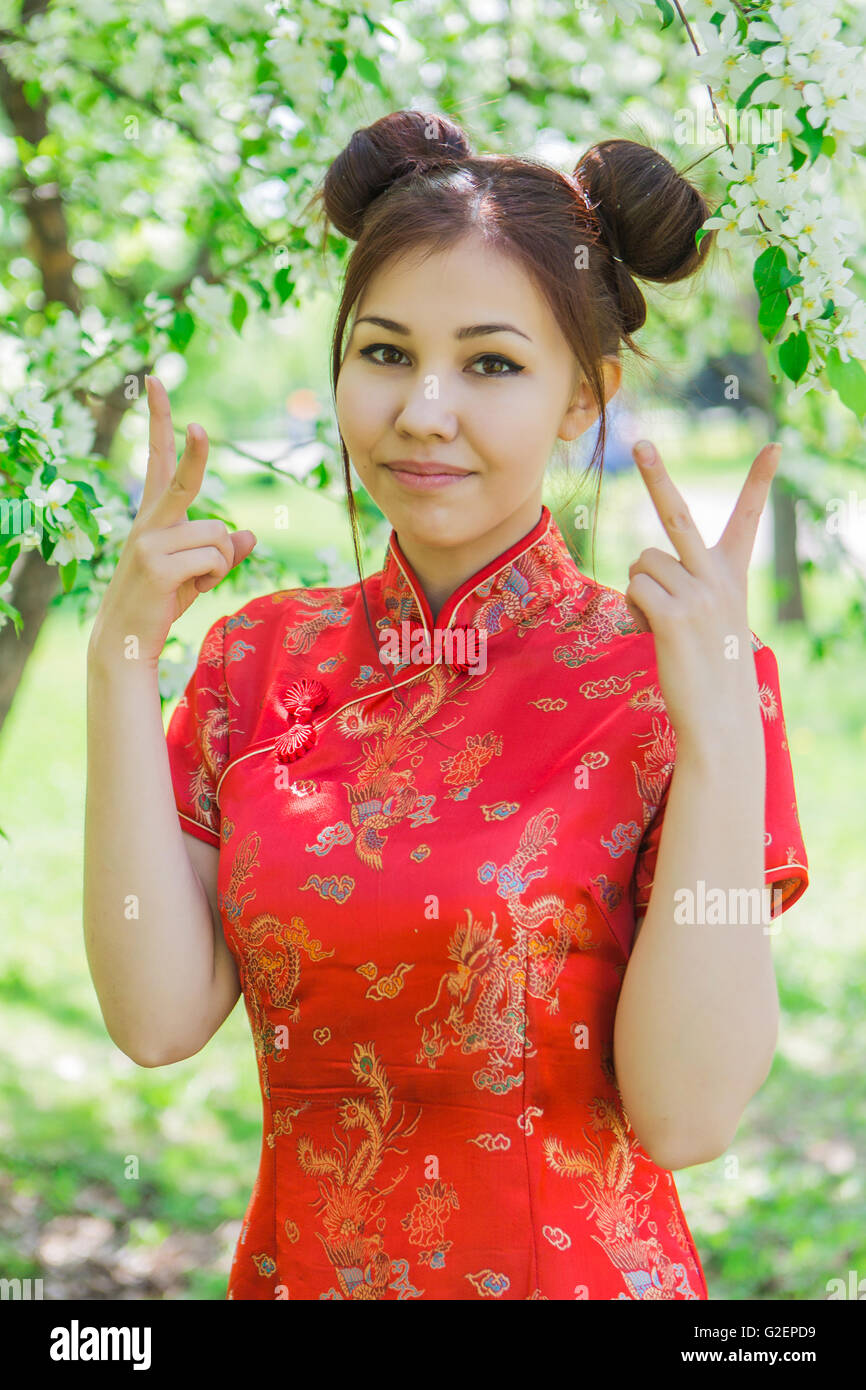 Beautiful asian girl in traditional chinese red dress near blooming ...