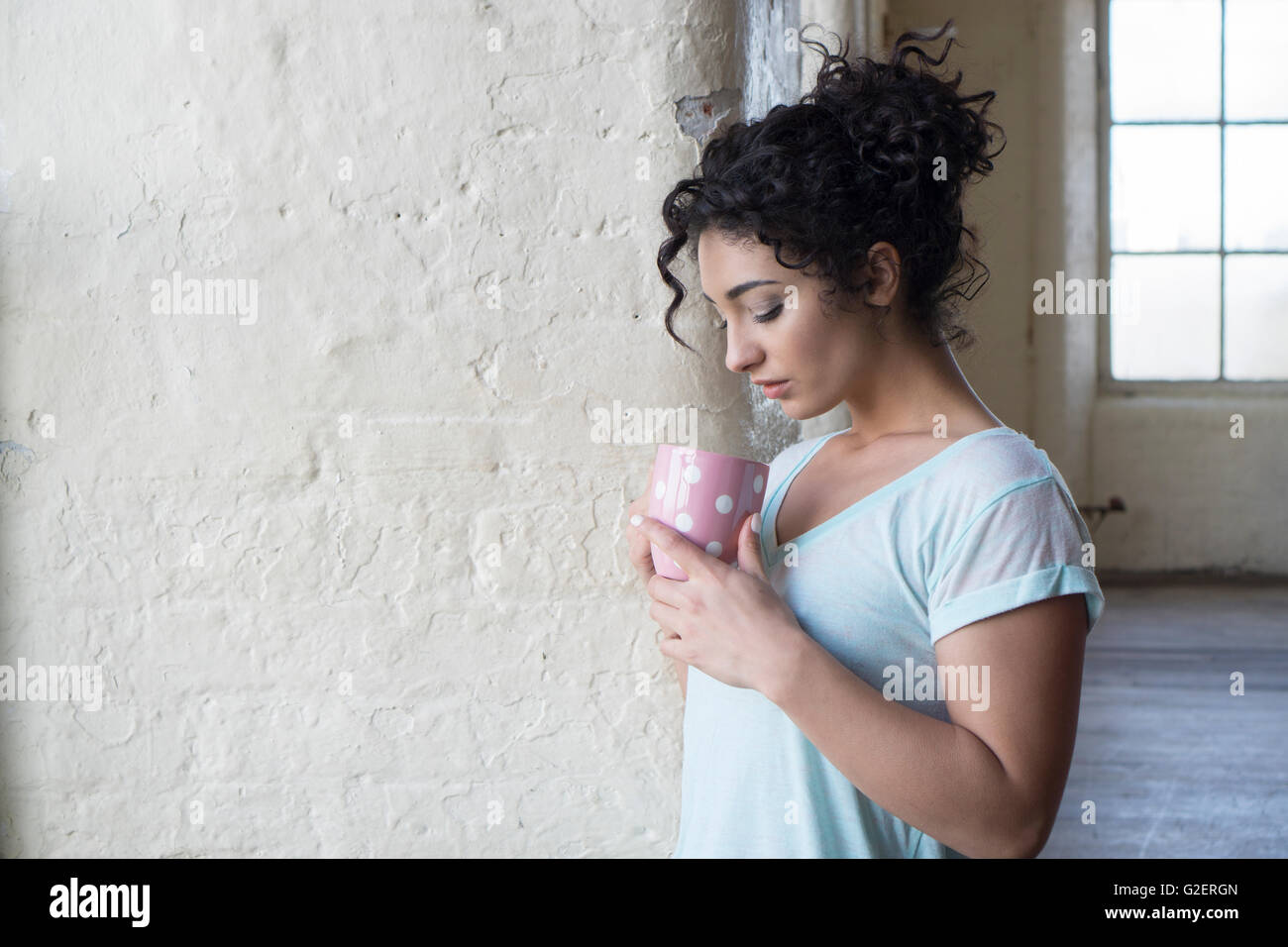 Sad young woman drinking coffee Stock Photo - Alamy