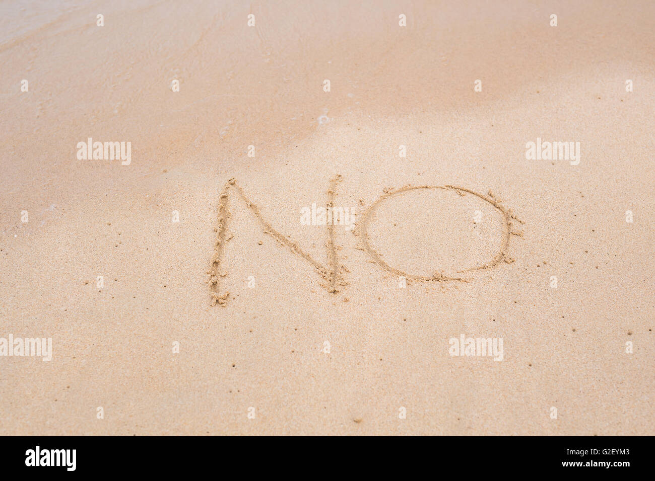 NO sign written in sand on beach texture sunny background. Closeup ...
