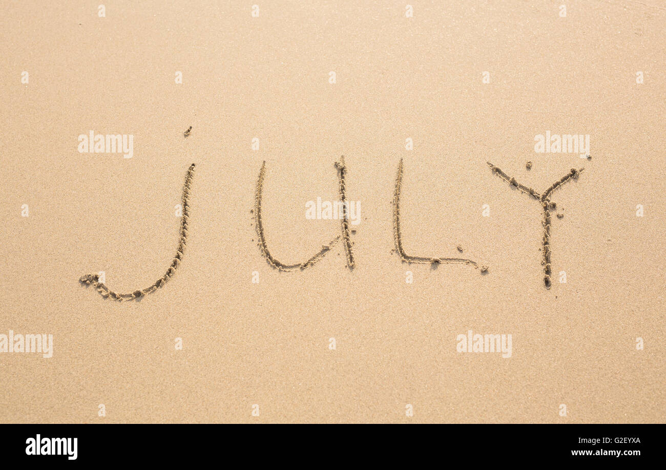 July - written in sand on beach texture, months year series Stock Photo ...