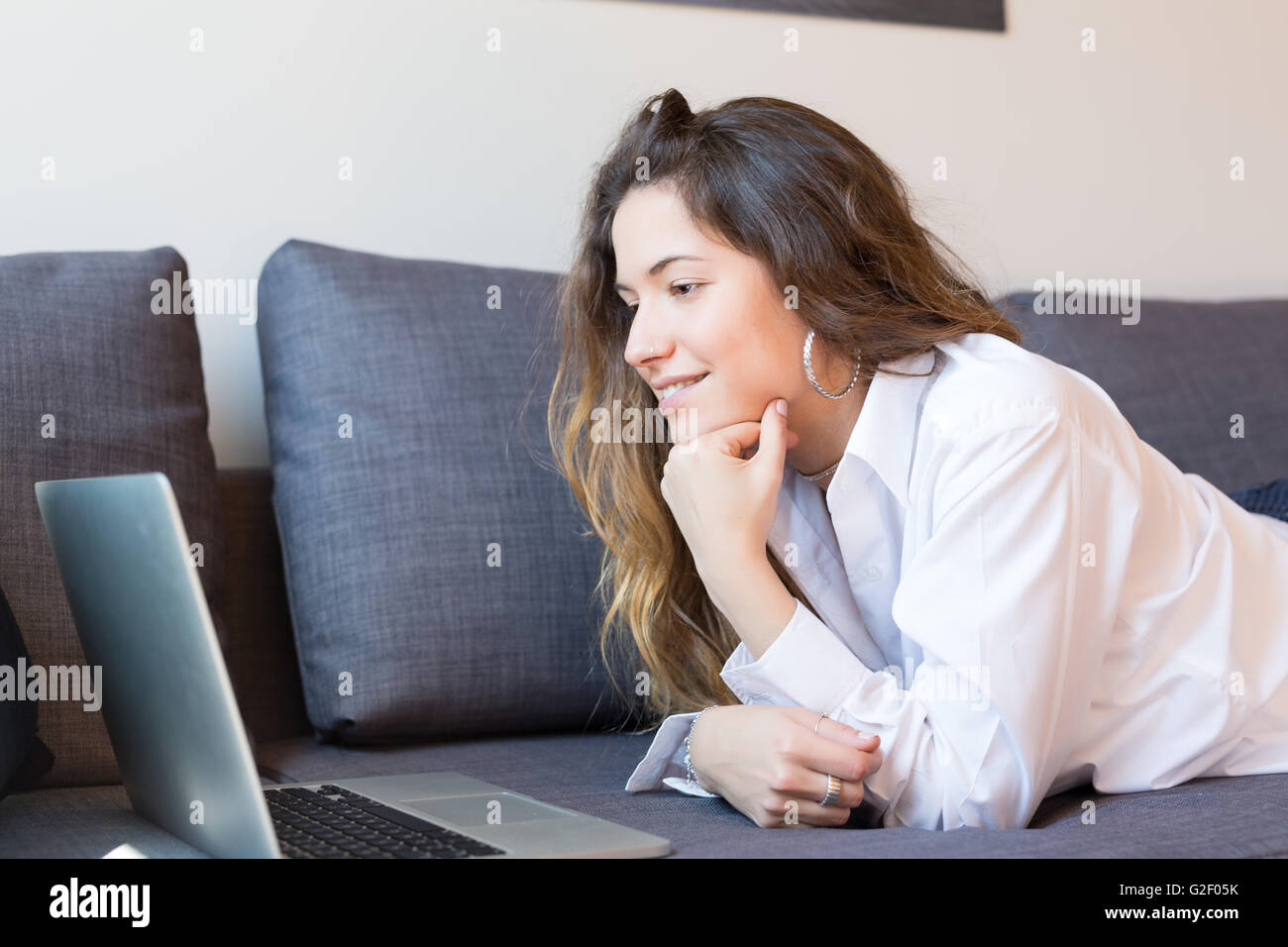 Beautiful woman relaxing with a computer Stock Photo - Alamy