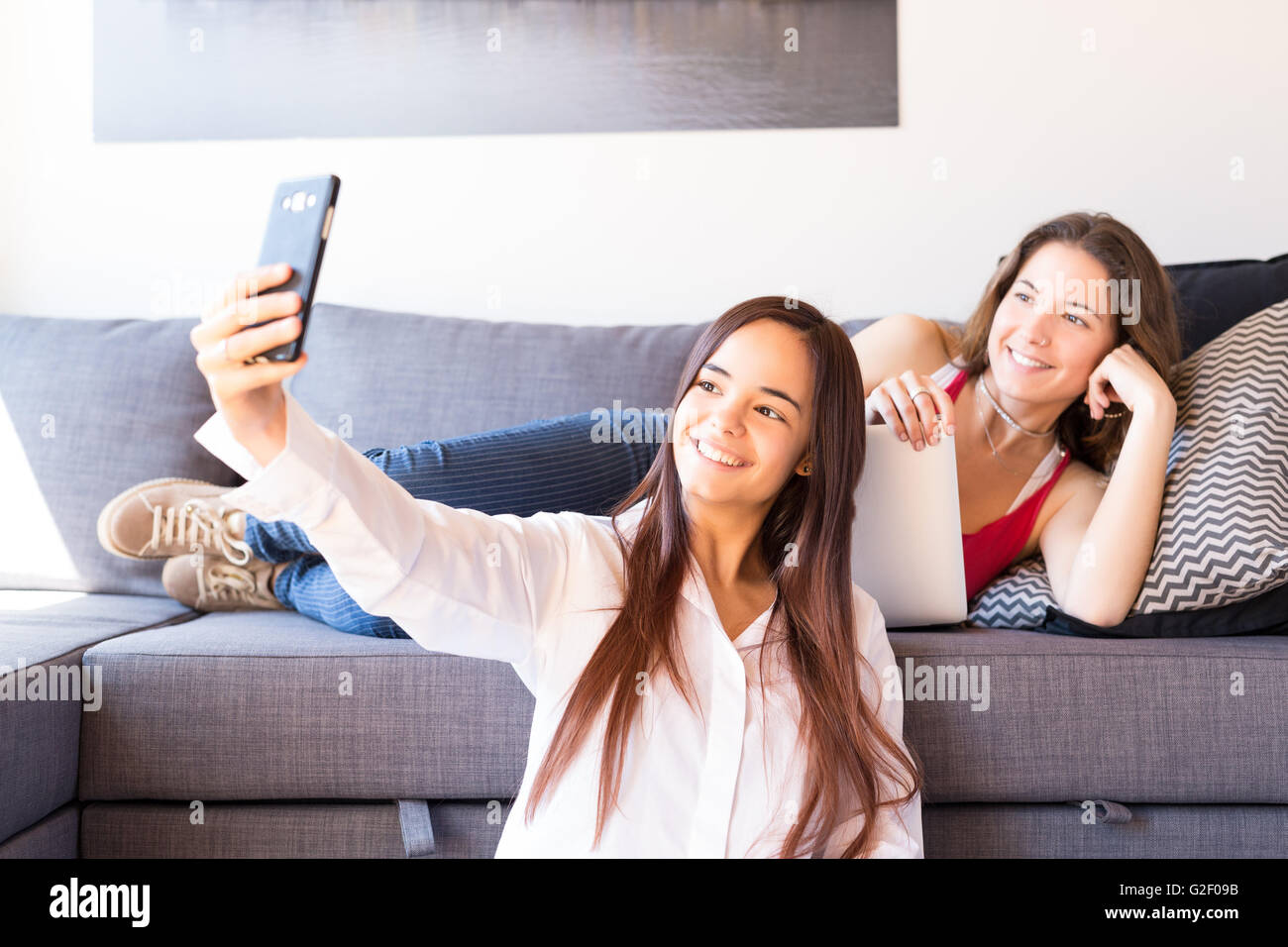 Happy friends relaxing at the living room Stock Photo - Alamy
