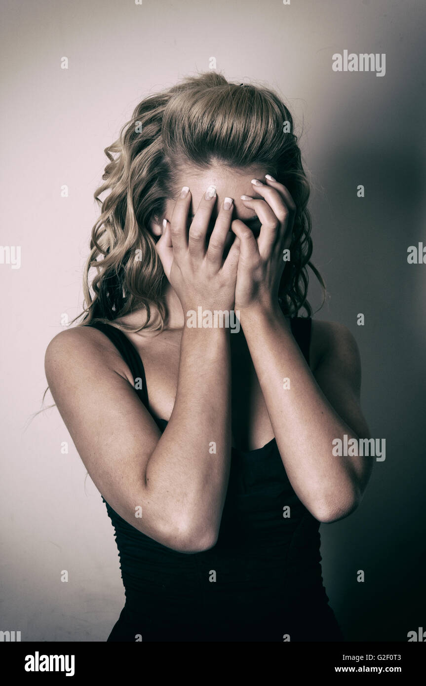 Young woman hiding face with hands Stock Photo - Alamy
