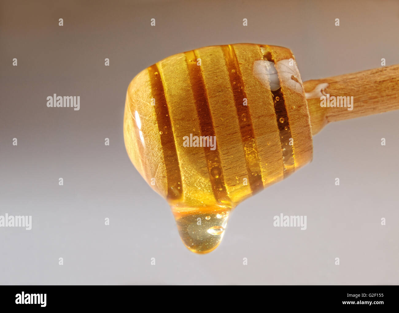 Honey dripping from a wooden honey with gradient background Stock Photo ...