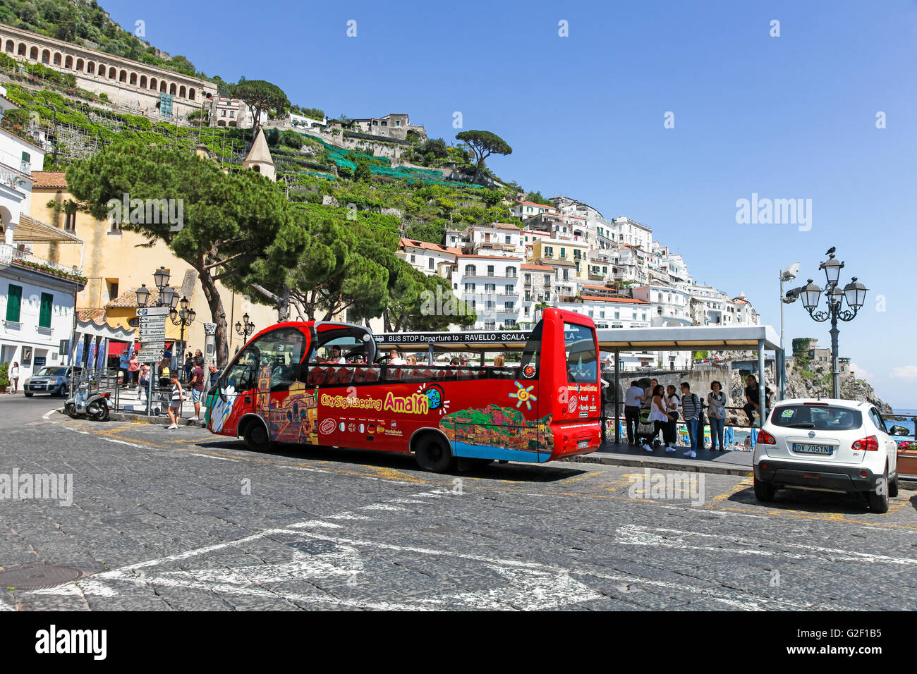 An open top sightseeing tourist bus waiting in the centre of Amalfi to ...