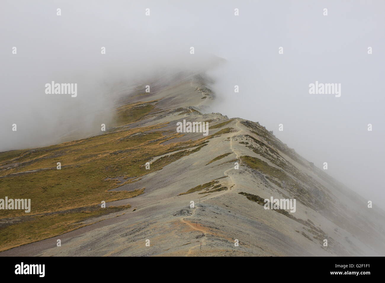 Path following a mountain ridge disappears in fog Stock Photo - Alamy