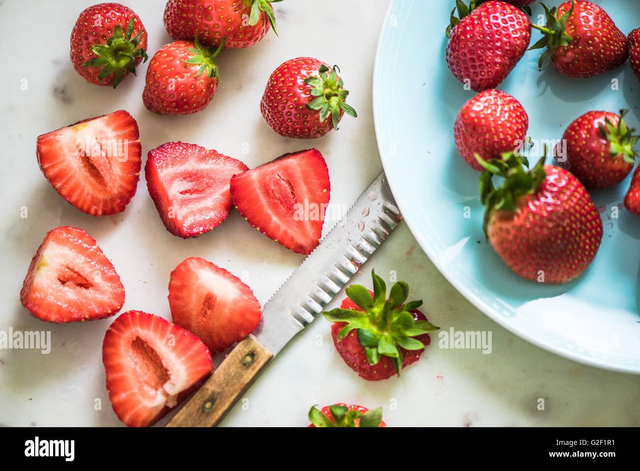 strawberries cut in half, view from above on marble top Stock Photo - Alamy