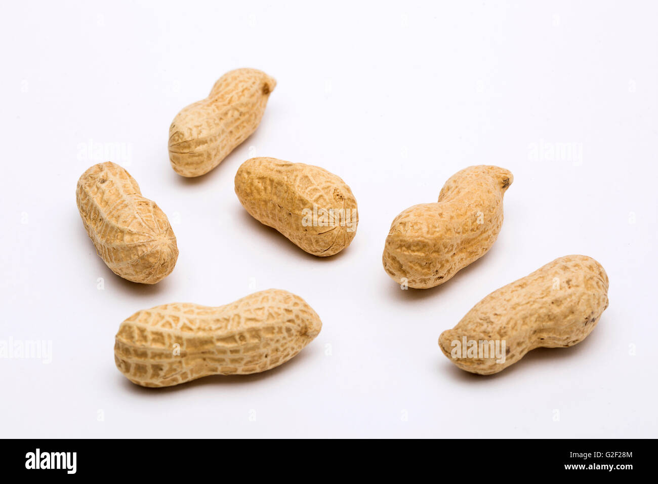 A few peanut shells scattered, isolated on white Stock Photo - Alamy