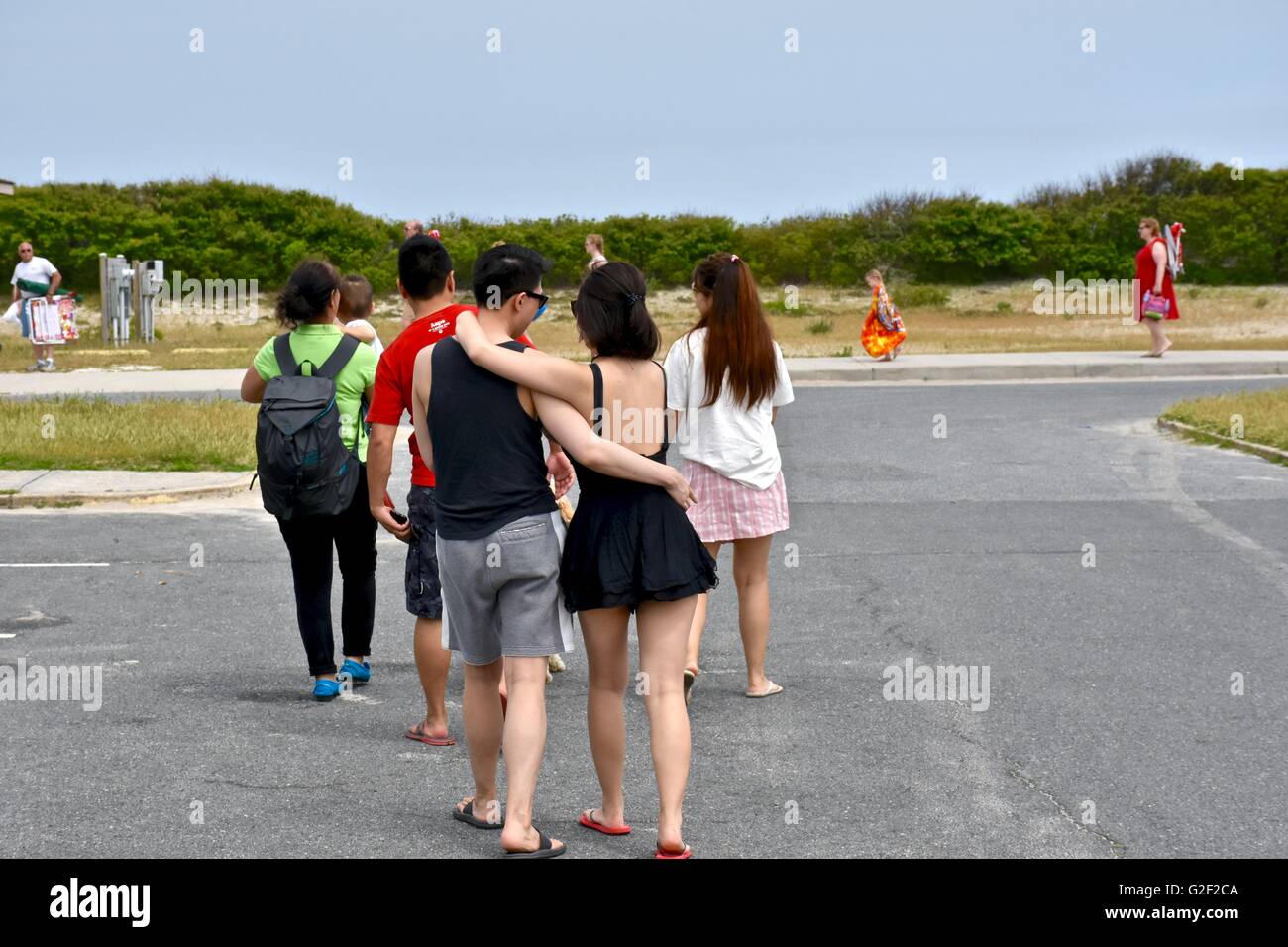 A couple with arms wrapped around each other walking to the beach Stock ...