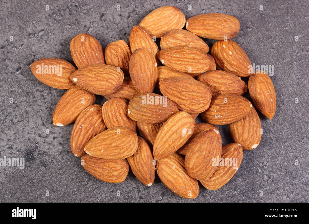 Heap of fresh healthy almonds on structure of concrete, concept for ...