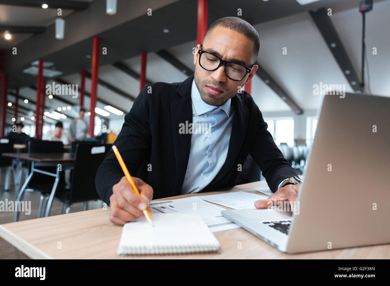 Young employee makes working notes at the office Stock Photo - Alamy