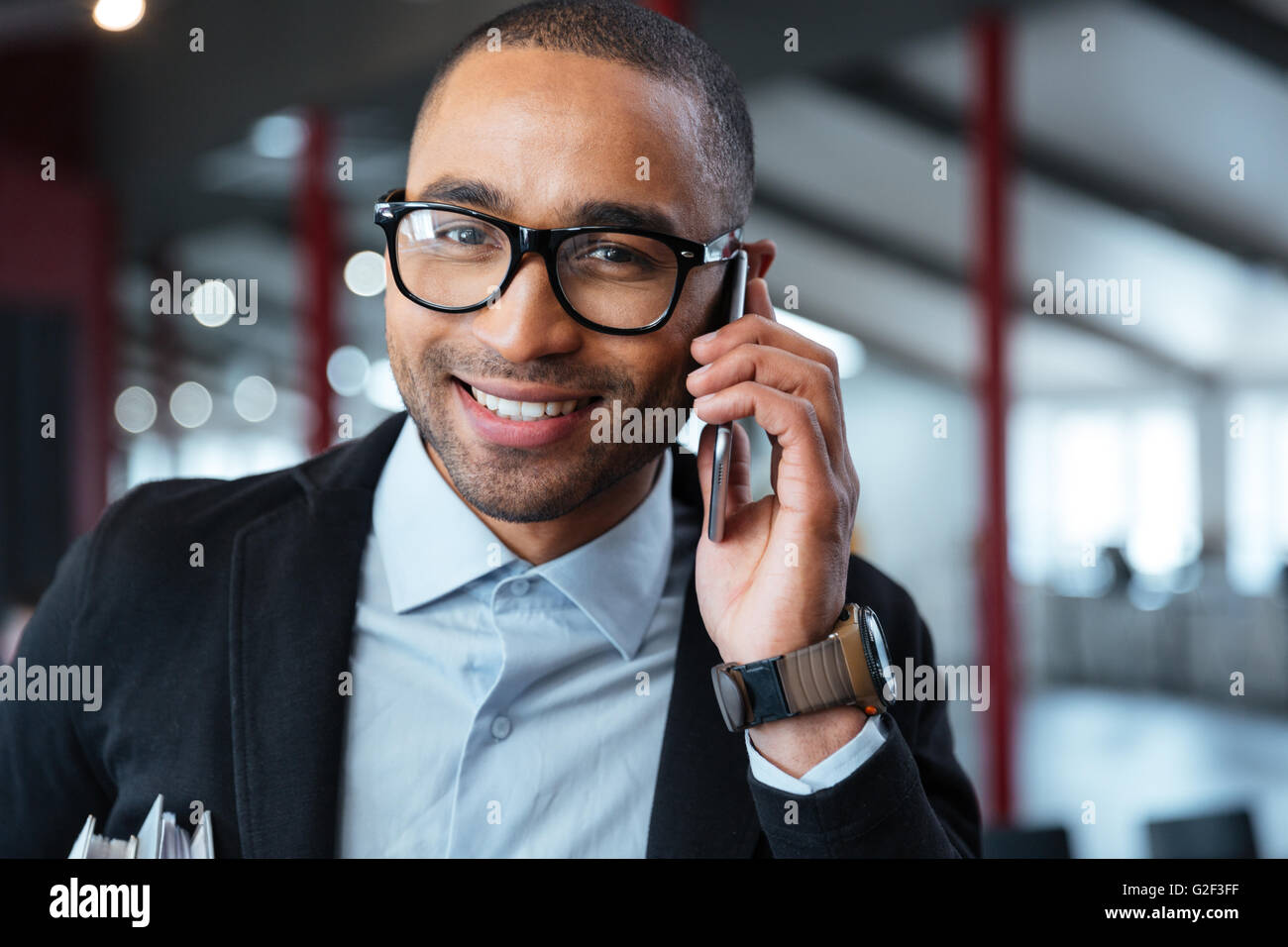 Close-up portrait of a businessman talking on the phone in the office ...