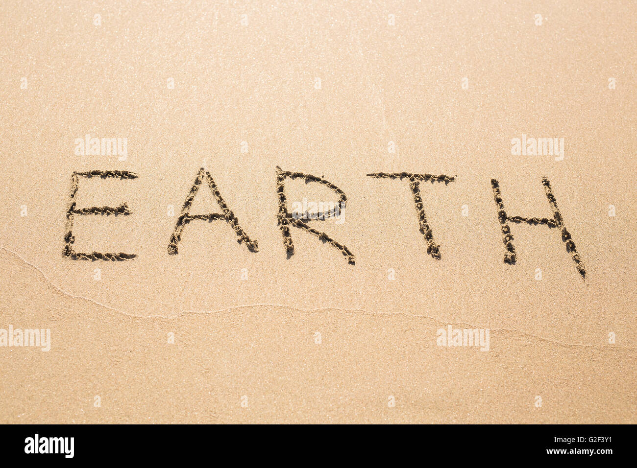 earth text on the sand Stock Photo - Alamy
