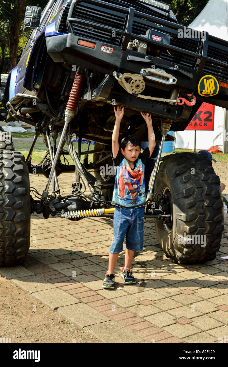Kid standing in front of extreme jeep at automotive event tumplek blek ...