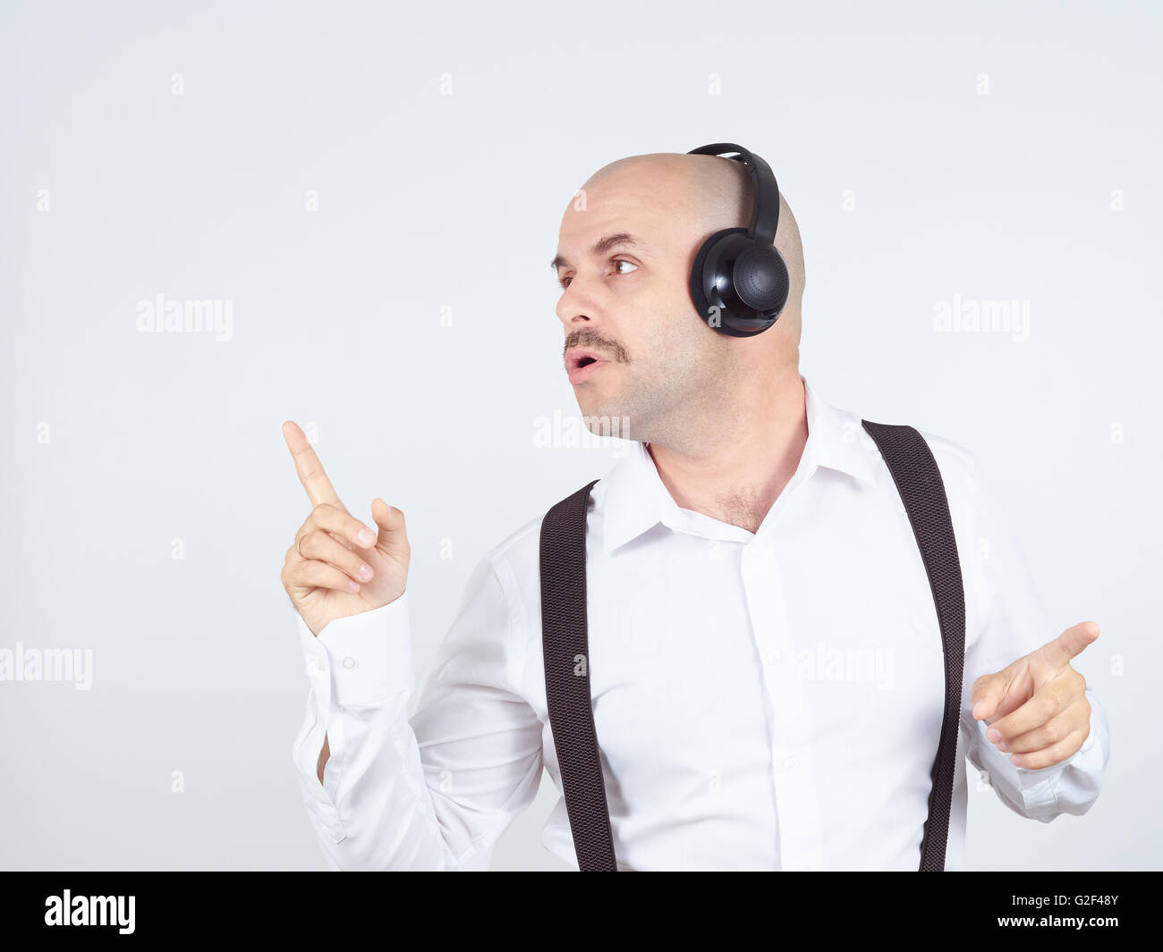 bald man with a mustache businessman listening to music on headphones ...