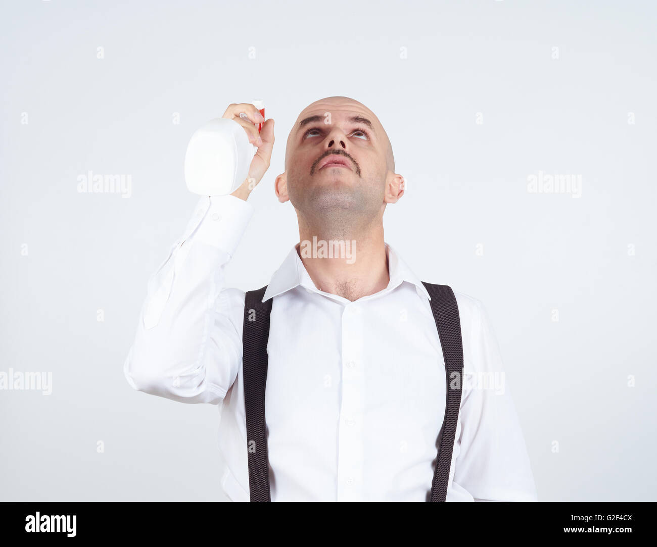 bald male cleaning worker spraying liquid detergent in front of him ...
