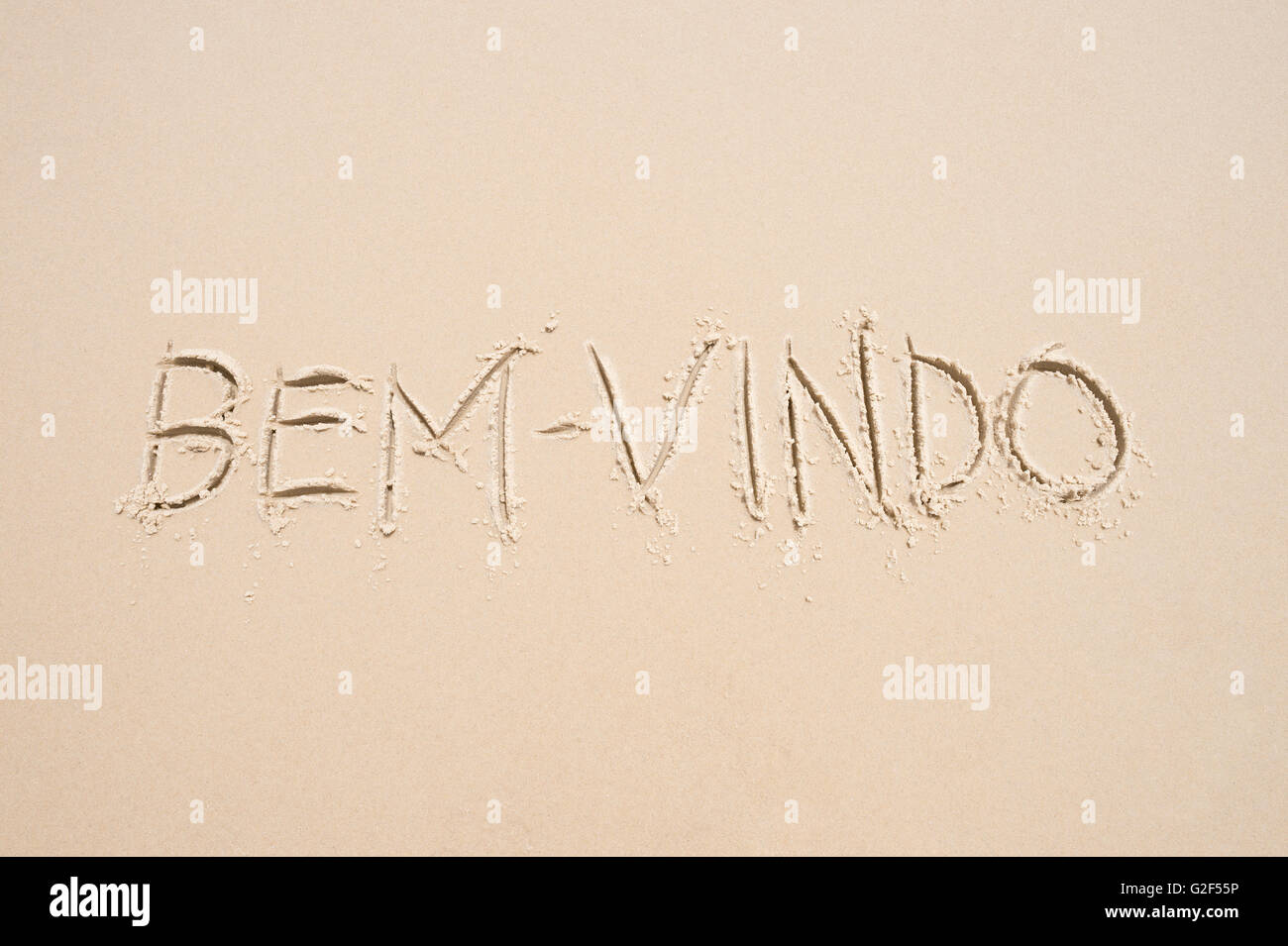 Bem-vindo welcome message in Portuguese handwritten in the sand on the ...