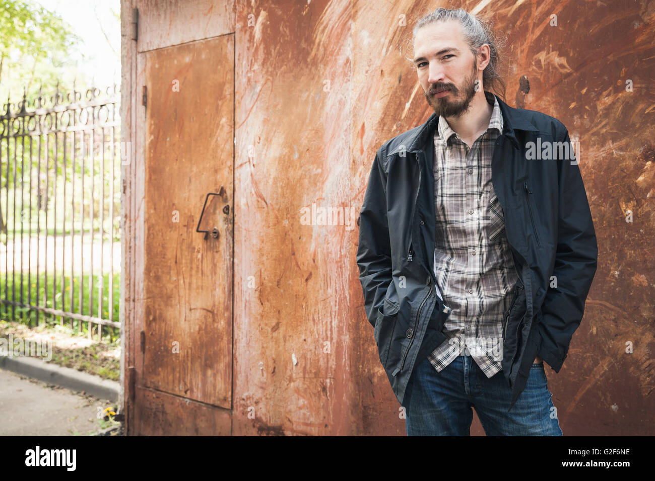 Outdoor portrait of young bearded Asian man in casual clothes over ...