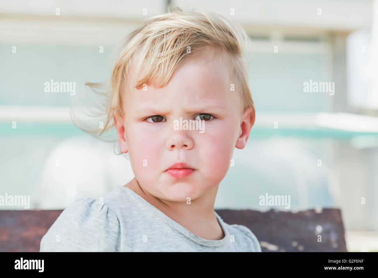 Outdoor closeup portrait of confused cute Caucasian blond baby girl ...