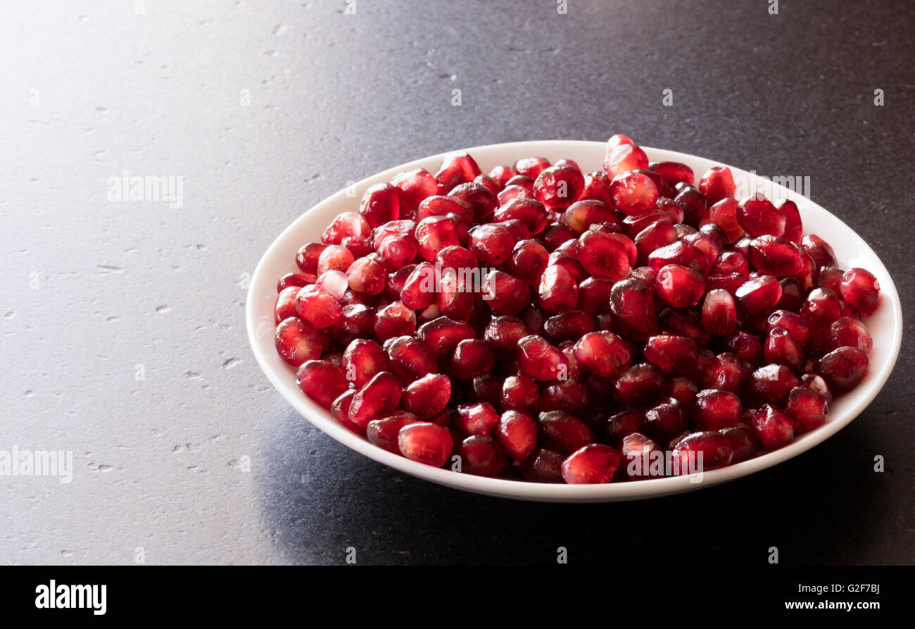 red pomegranate grains on a black stone Stock Photo - Alamy