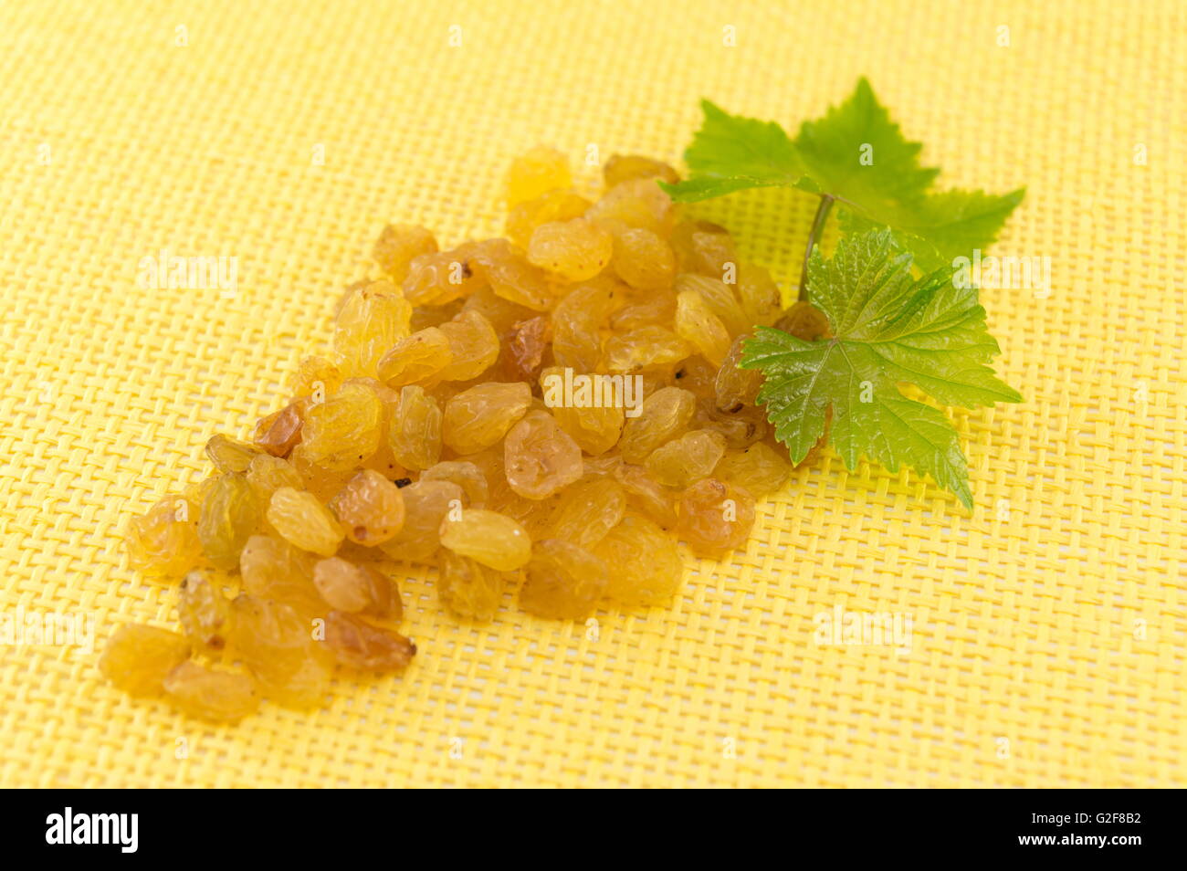 Raisins forming a grape cluster on yellow background Stock Photo - Alamy