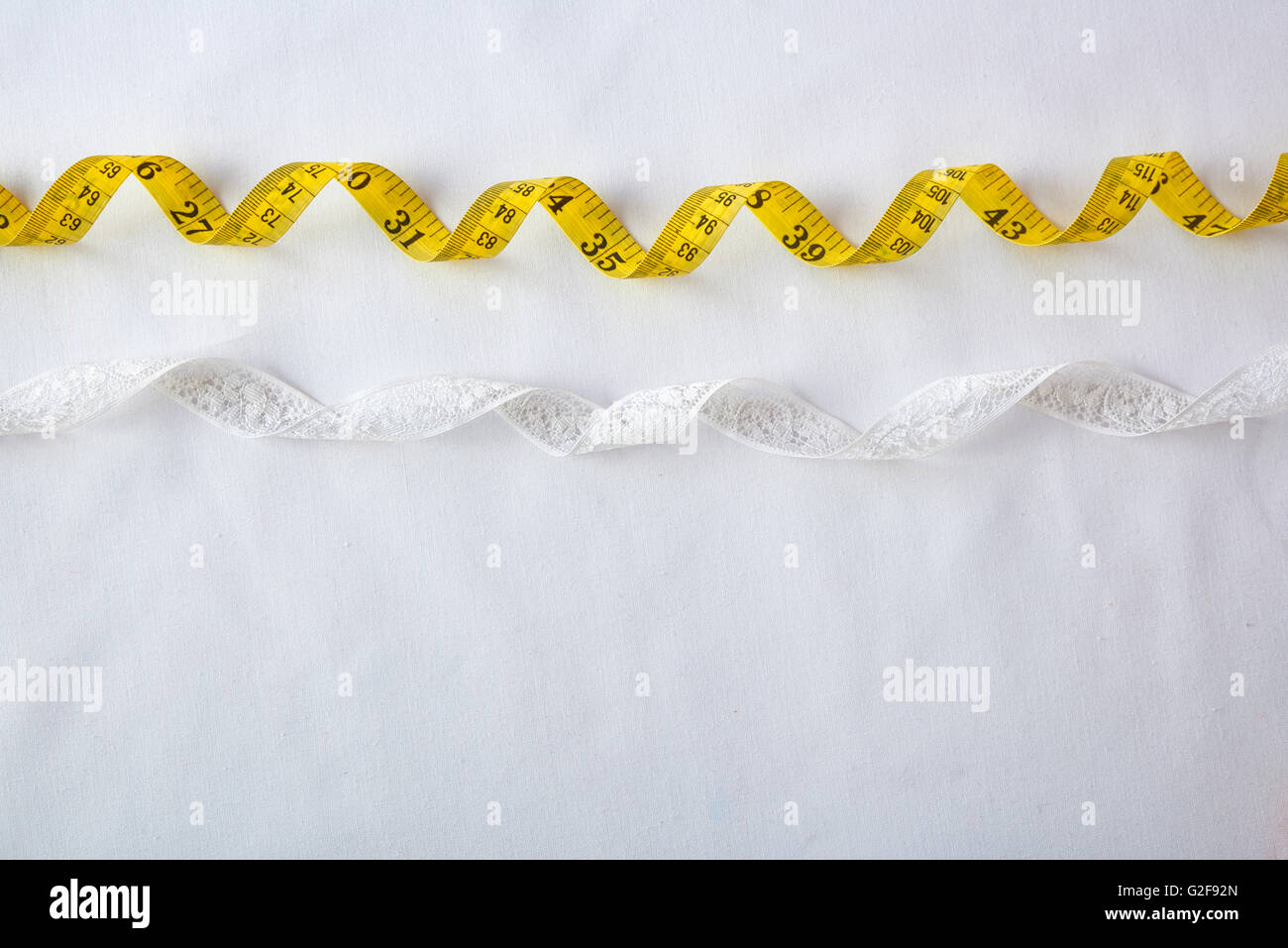 Measuring tape and ribbon lace isolated on white cloth. Horizontal ...
