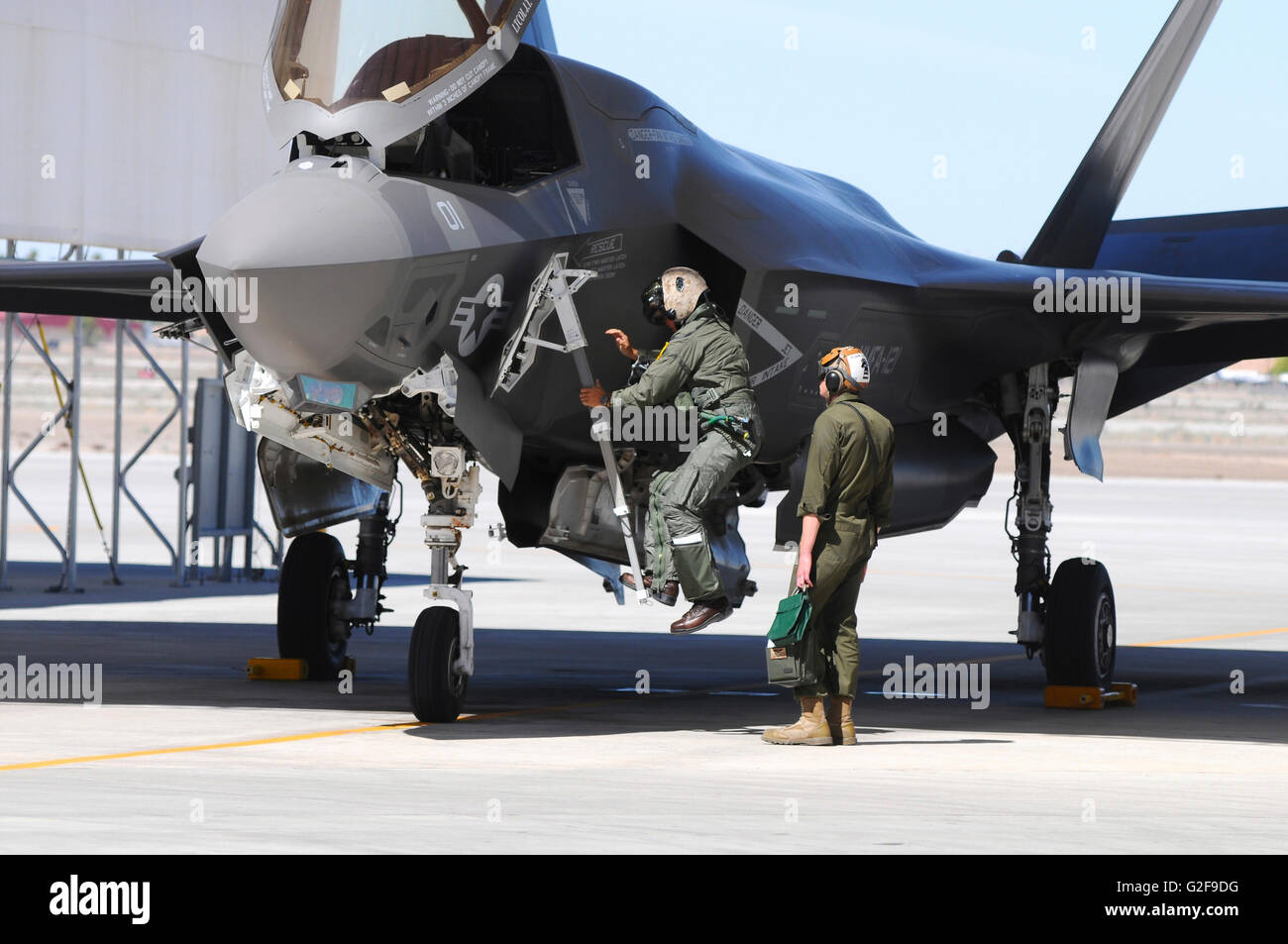 A U.S. Marine Corps pilot from VMFA-121 climbs on an F-35B Lightning II ...