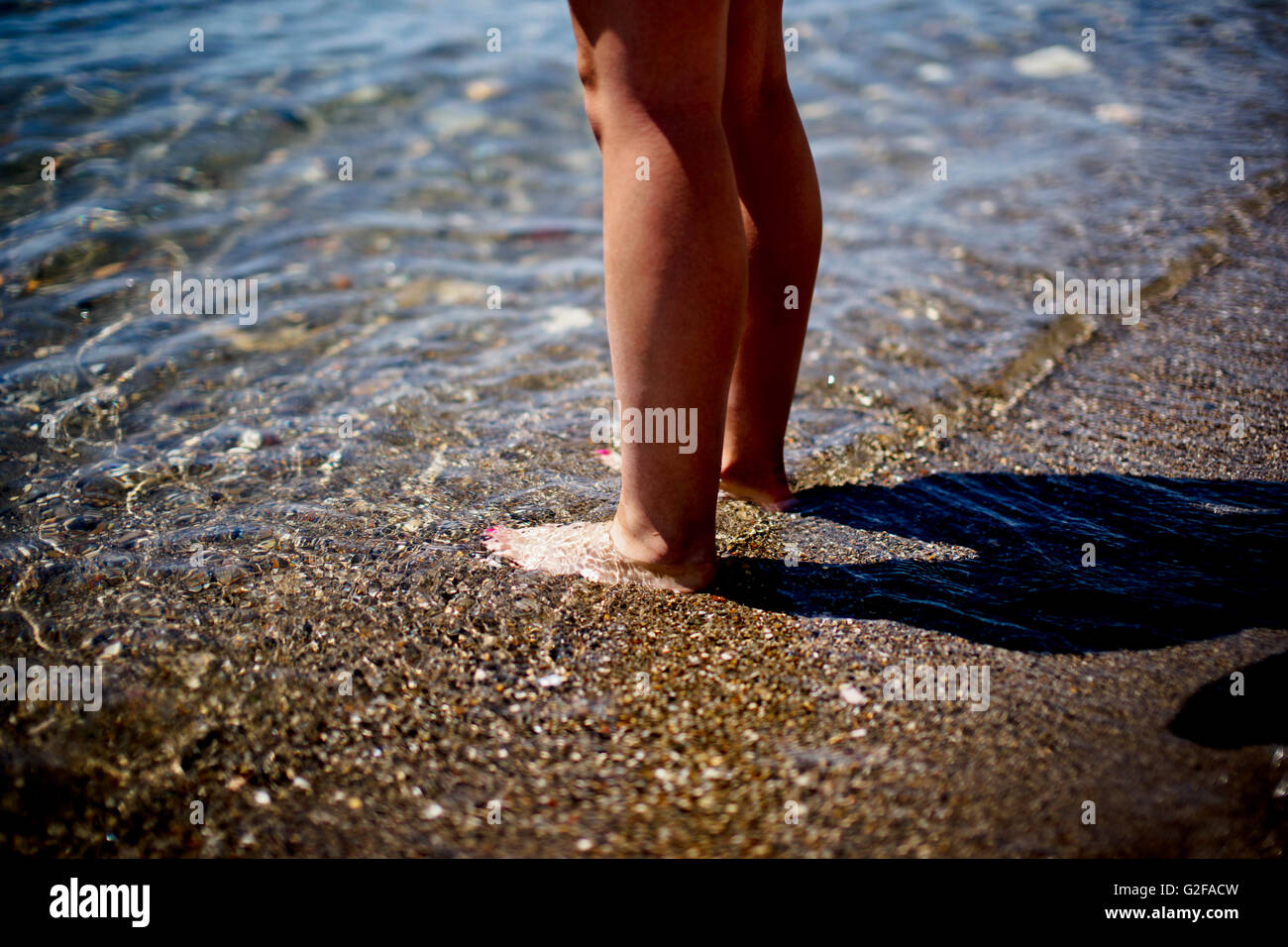 Young Adult Woman's Legs standing in Shallow Water Stock Photo - Alamy