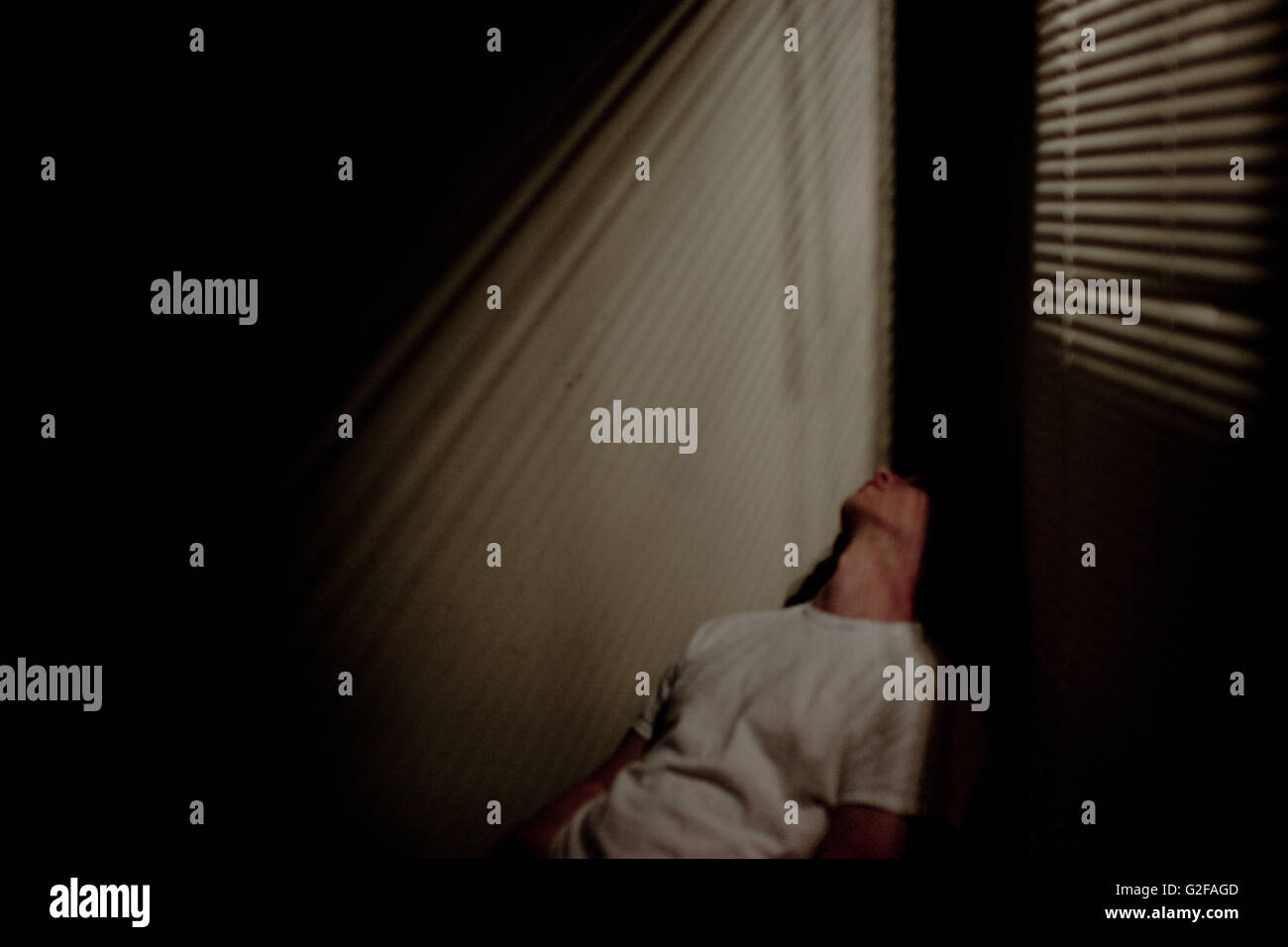 Young Depressed Man Slumped in Corner of Darkened Room Stock Photo - Alamy