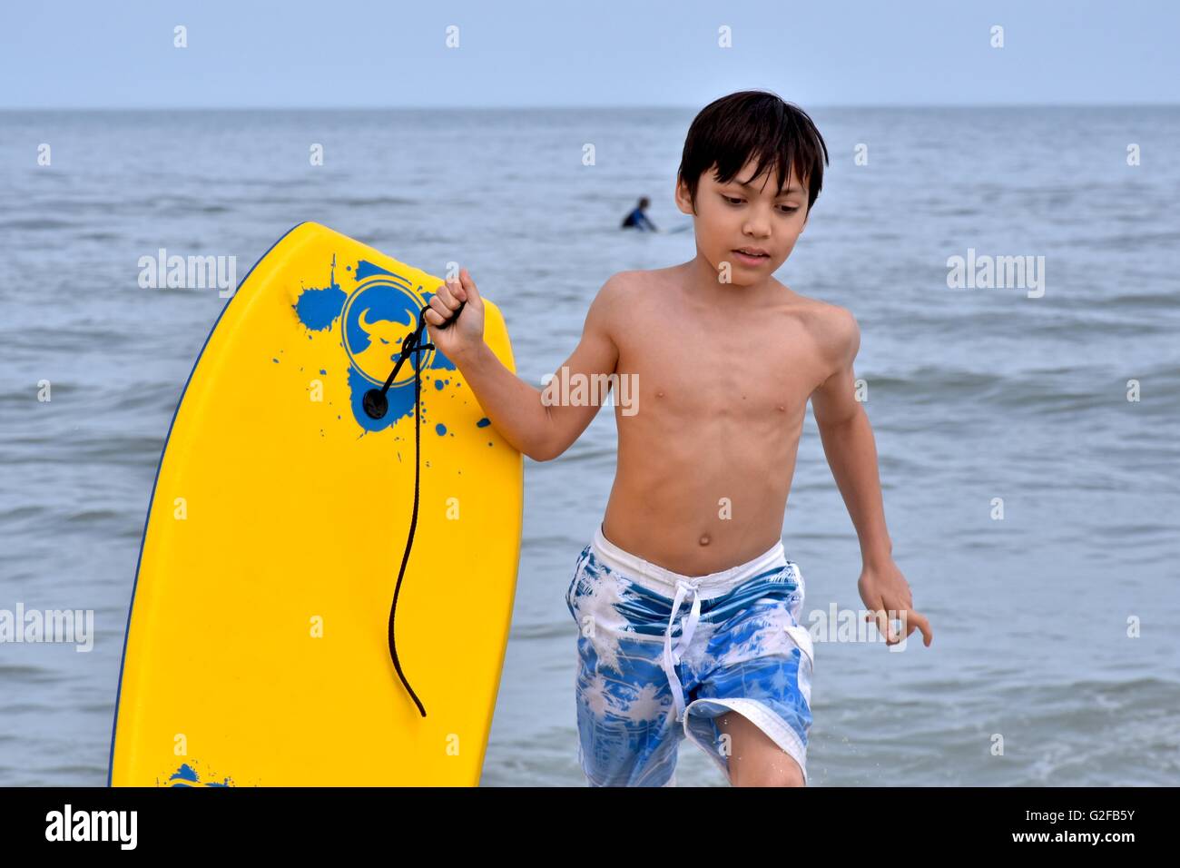 A boy boogie boarding while at the beach Stock Photo - Alamy