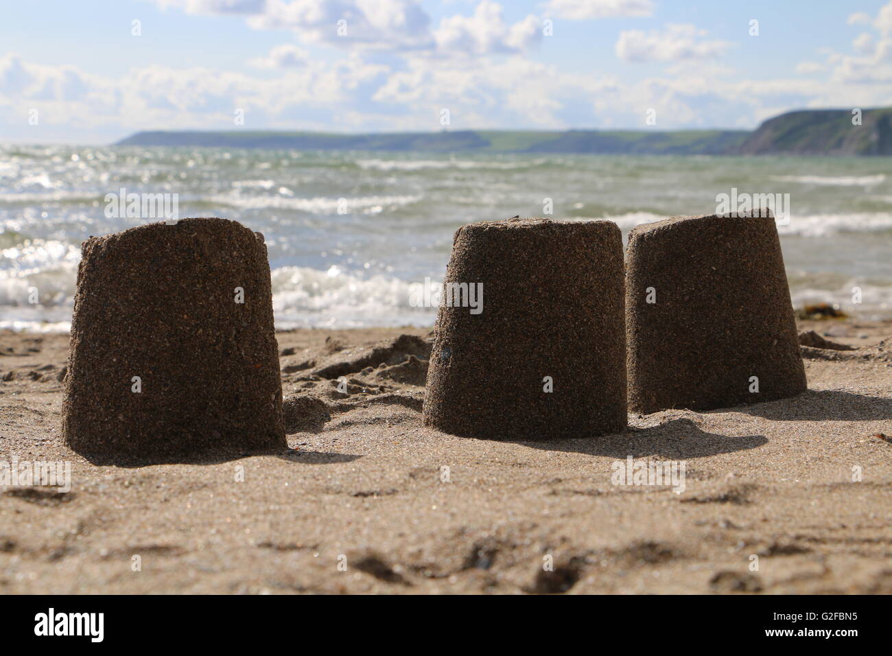 Three sandcastle towers on a beach Stock Photo - Alamy