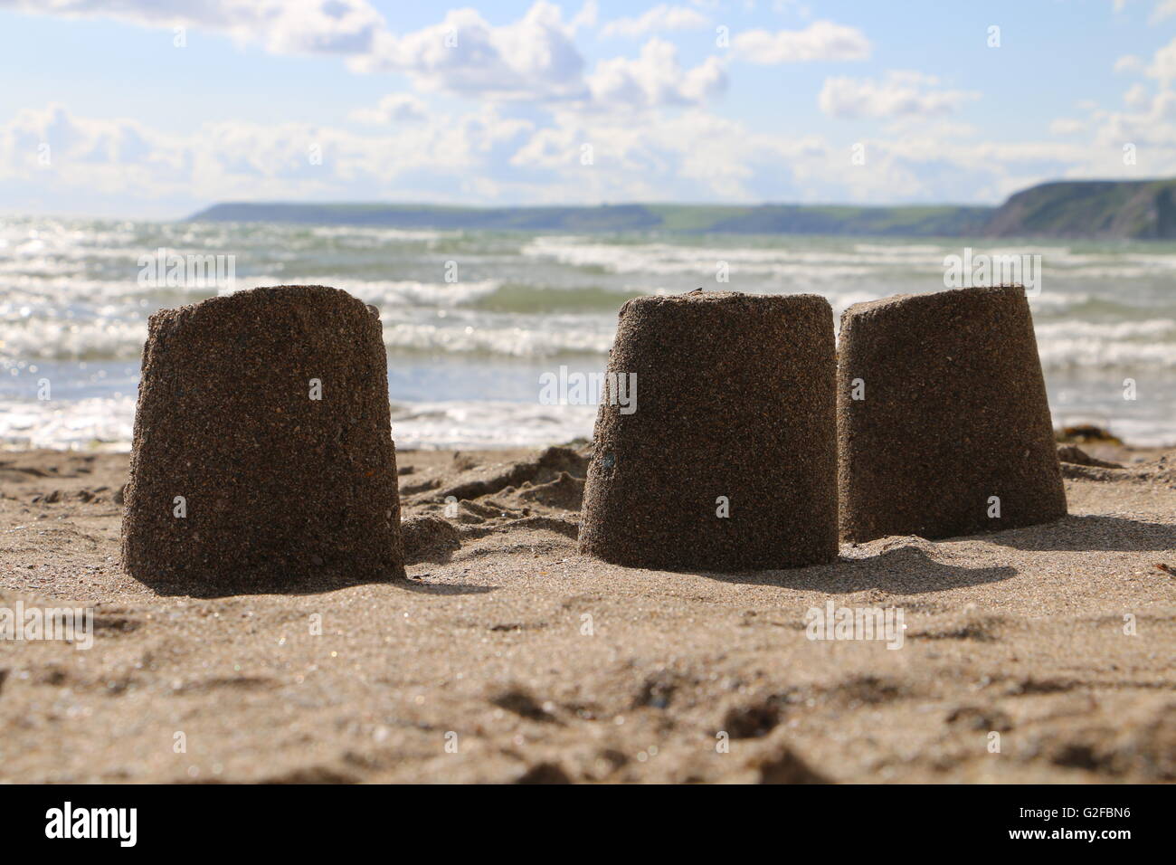 Three sandcastle towers on a beach Stock Photo - Alamy