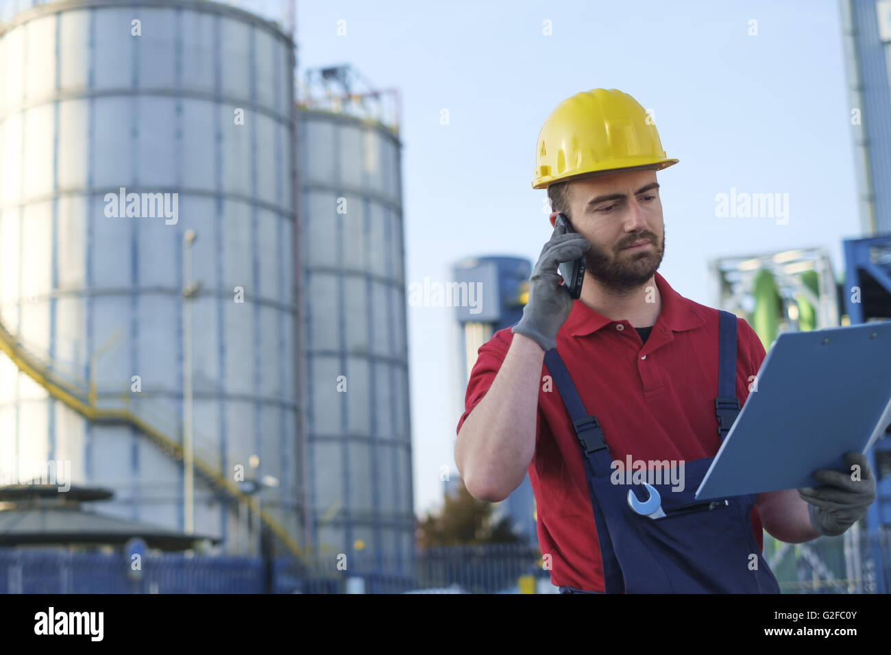 laborer outside a factory working dressed with safety overalls ...
