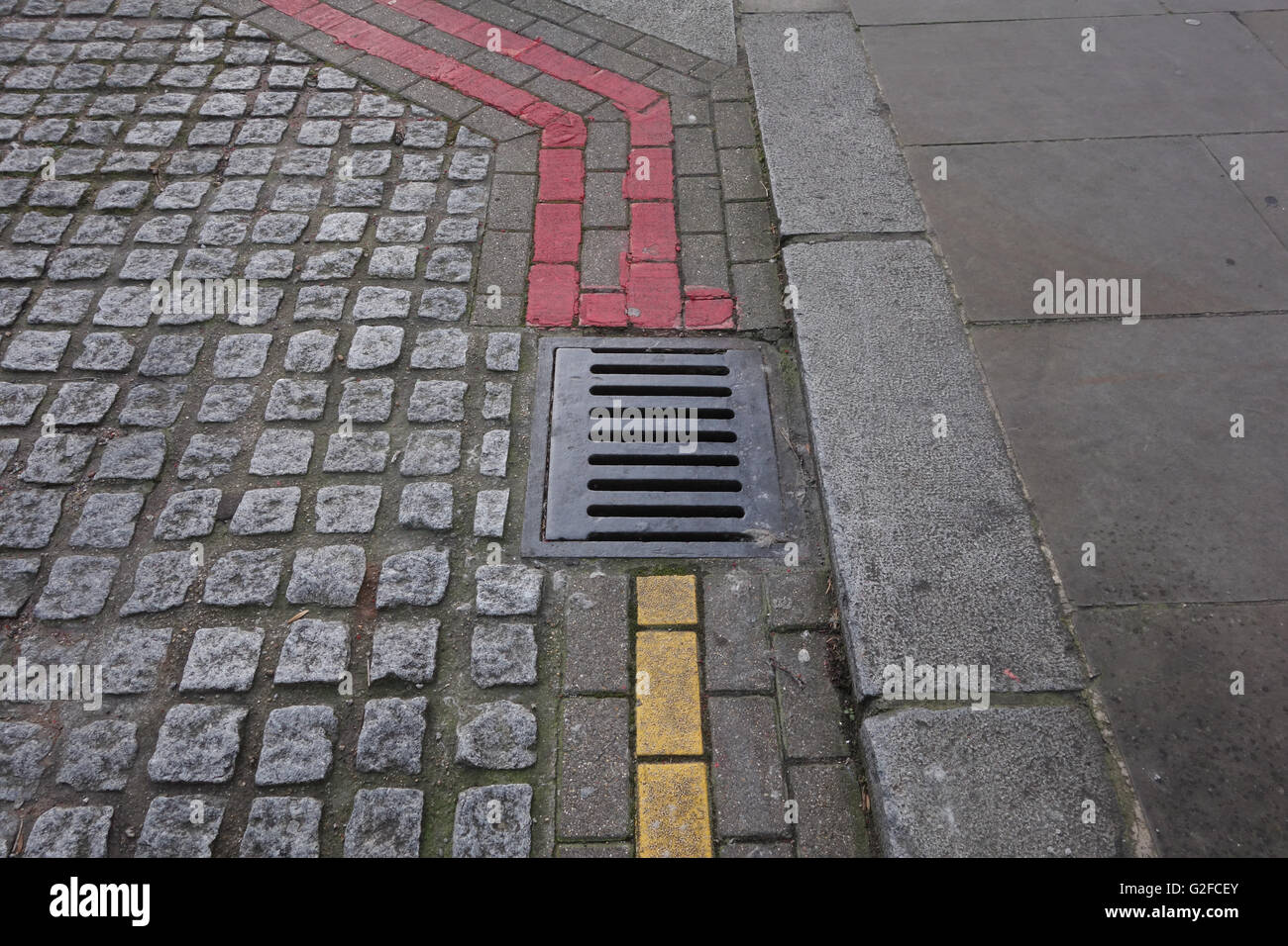 Drain, pavement, cobbled road and line markings Stock Photo - Alamy