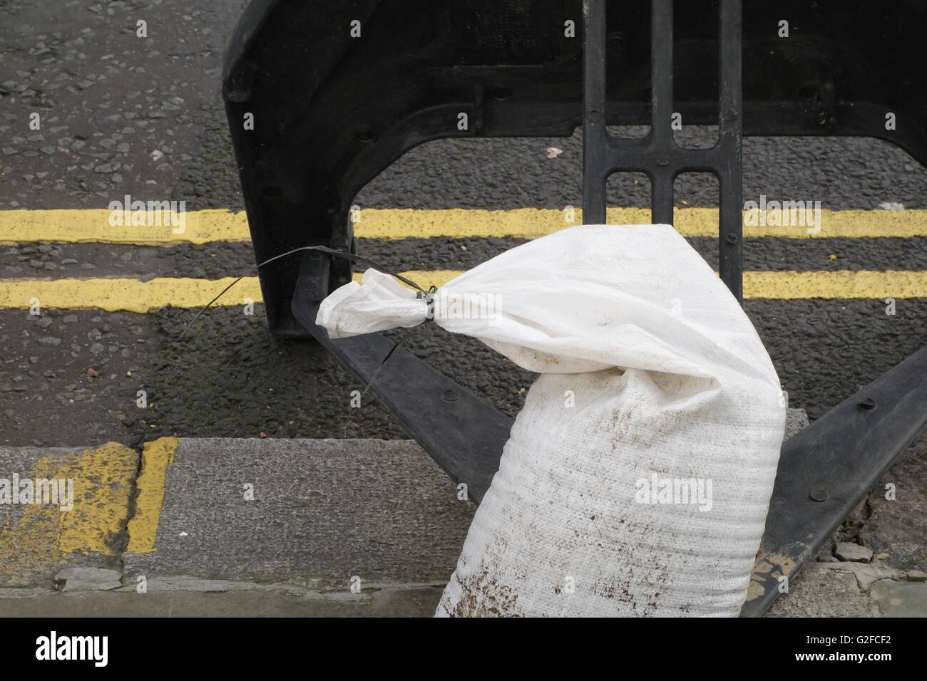 Roadwork sign held in place at side of road with a sandbag Stock Photo ...
