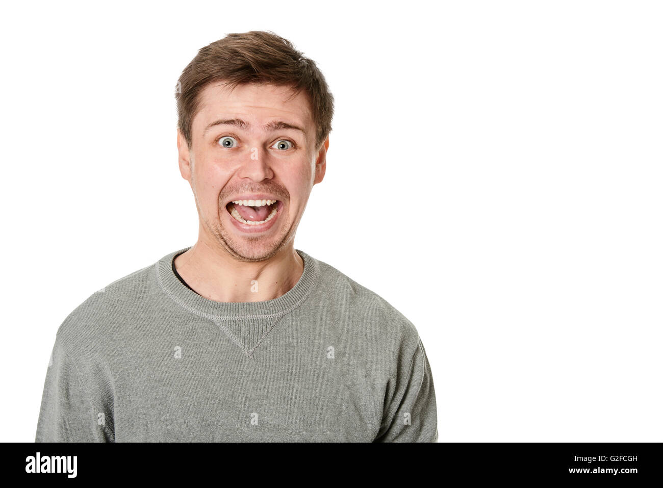Young man with manic expression, on gray background Stock Photo - Alamy