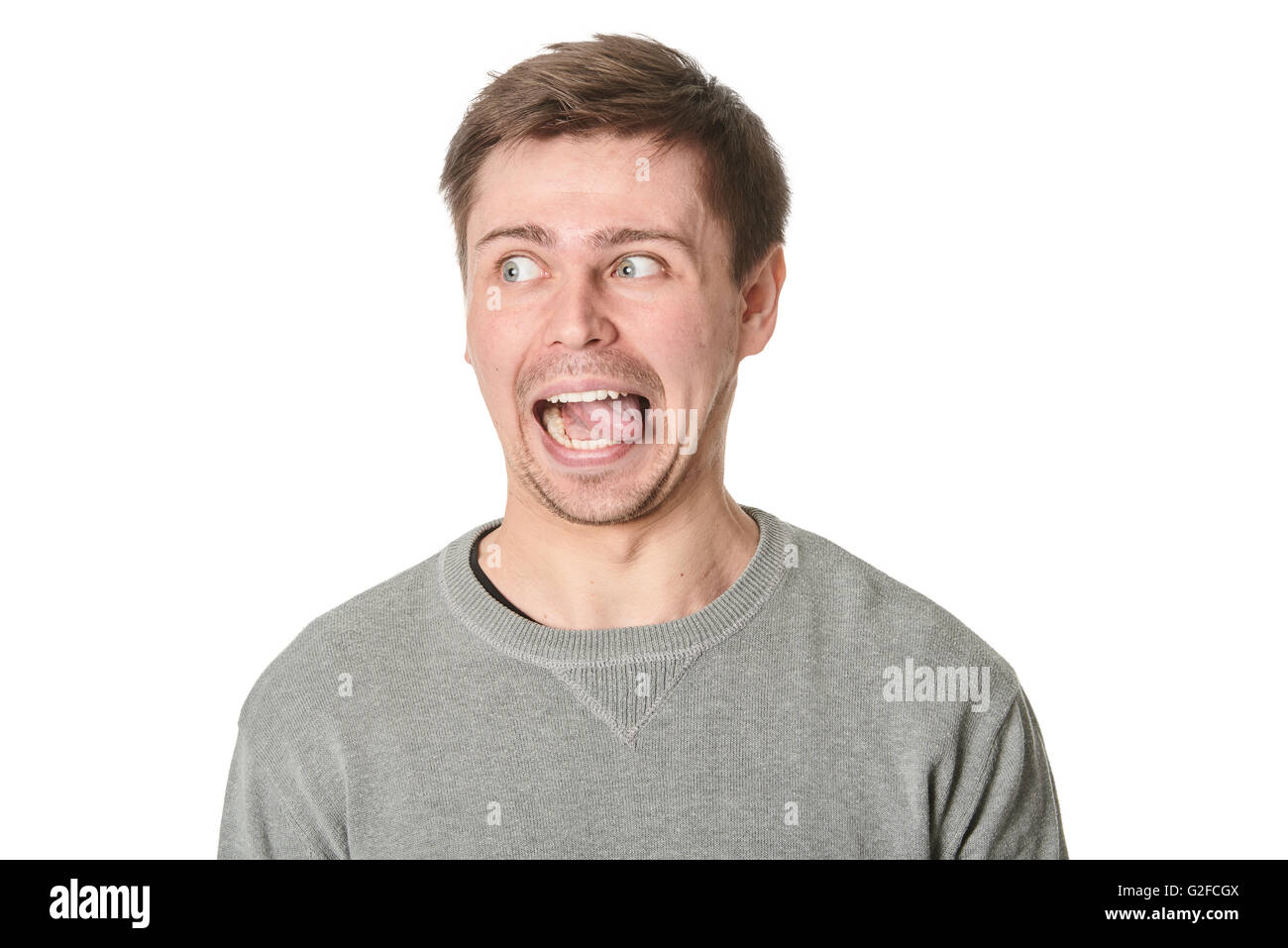 Young man with manic expression, on gray background Stock Photo - Alamy