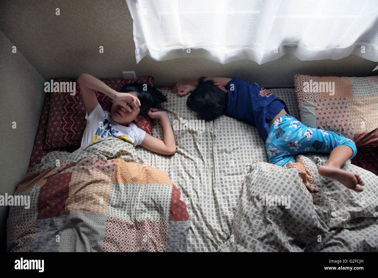 Morning time. 2 Sleeping boys start to wake-up Stock Photo - Alamy