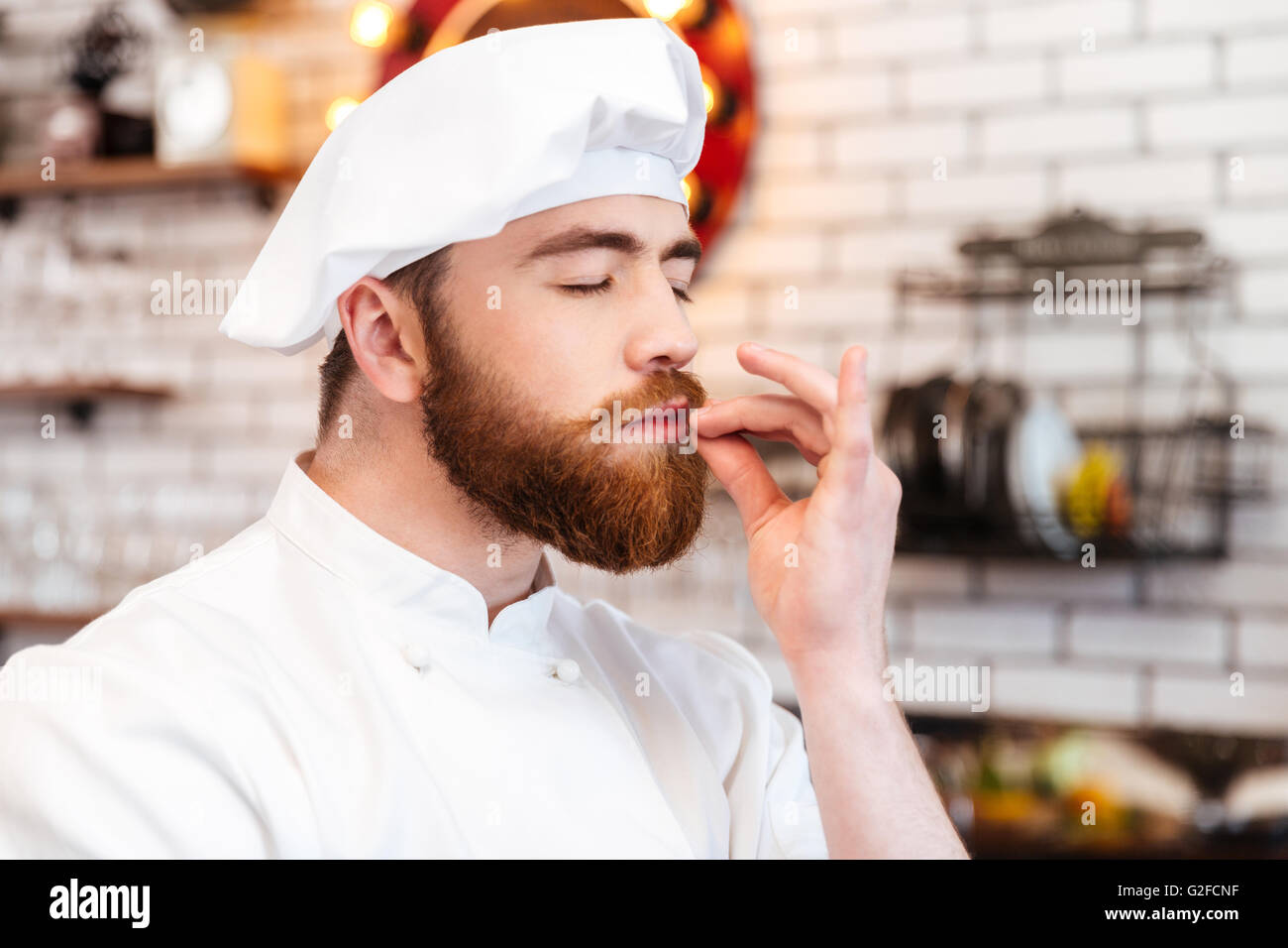 Happy handsome chef cook smelling aroma of food on the kitchen Stock ...