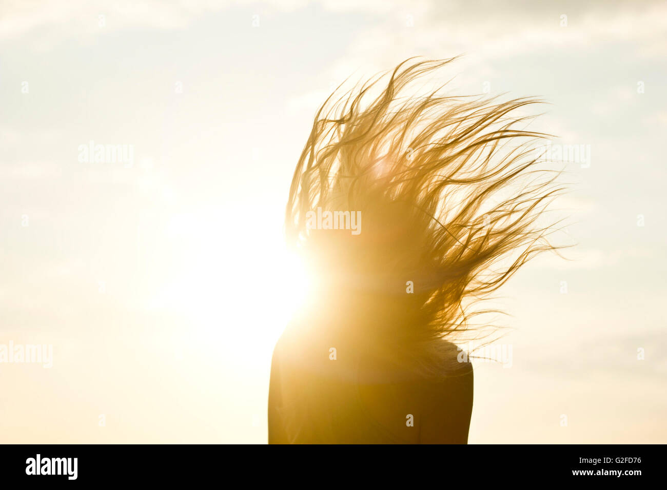silhouette of girl's hair up against the yellow sun rays Stock Photo ...