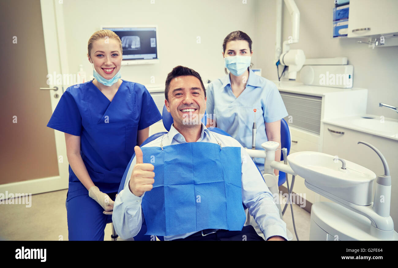 happy female dentists with man patient at clinic Stock Photo - Alamy