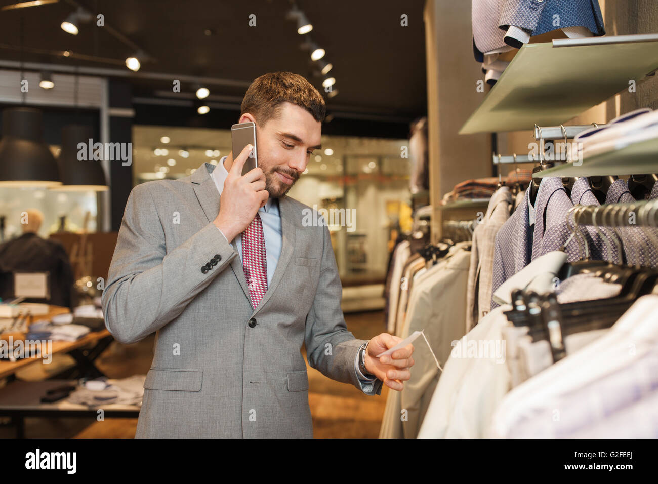 happy man calling on smartphone at clothing store Stock Photo - Alamy