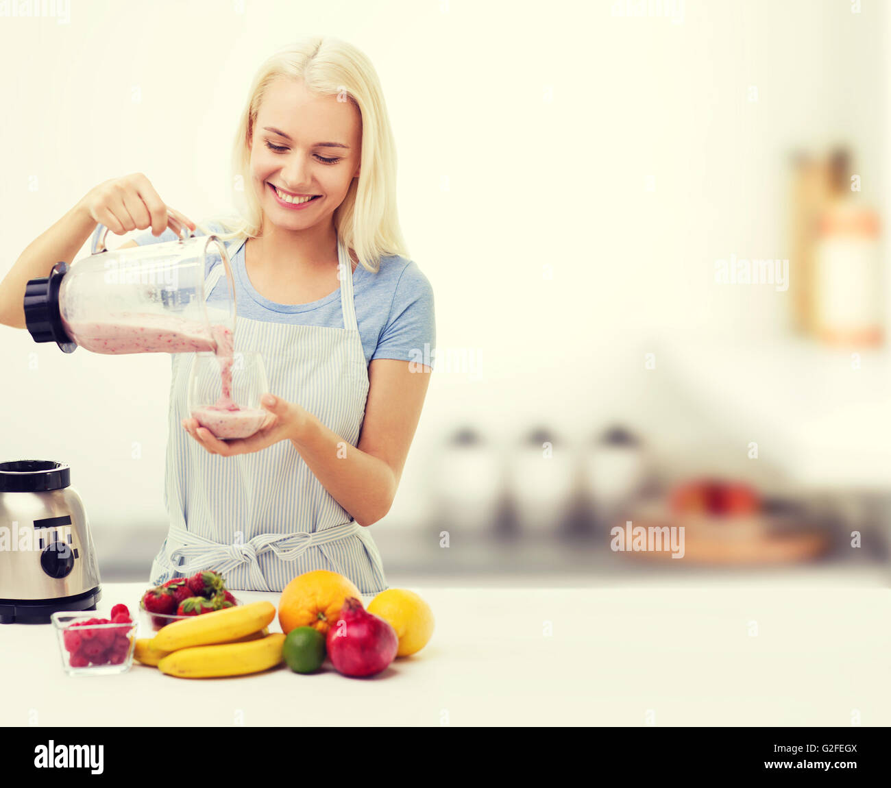 smiling woman with blender and fruit milk shake Stock Photo - Alamy