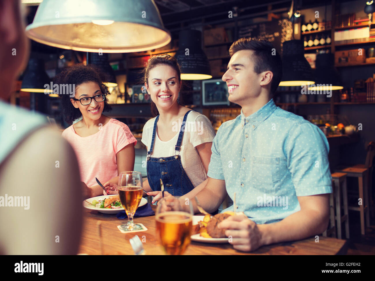 happy friends eating and drinking at bar or pub Stock Photo - Alamy