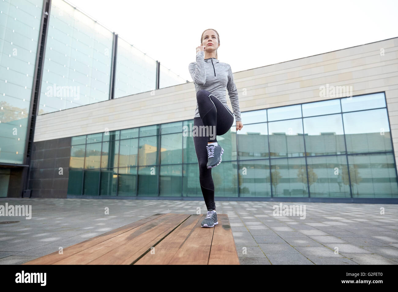 woman making step exercise on city street bench Stock Photo - Alamy