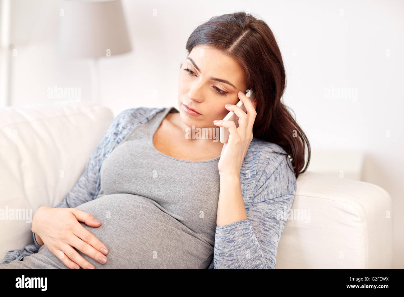 sad pregnant woman calling on smartphone at home Stock Photo - Alamy