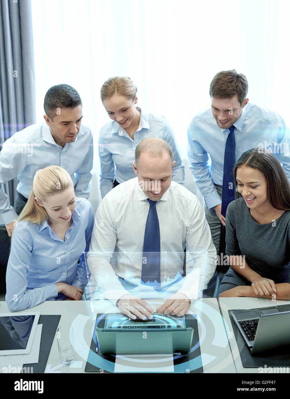 smiling business people with laptop in office Stock Photo - Alamy