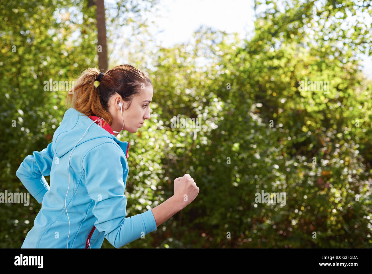 Portrait of a runner listening to music on headphones while running ...