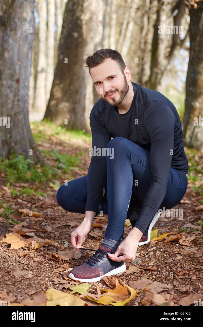 Runner doing stretching outside in autumn Stock Photo - Alamy