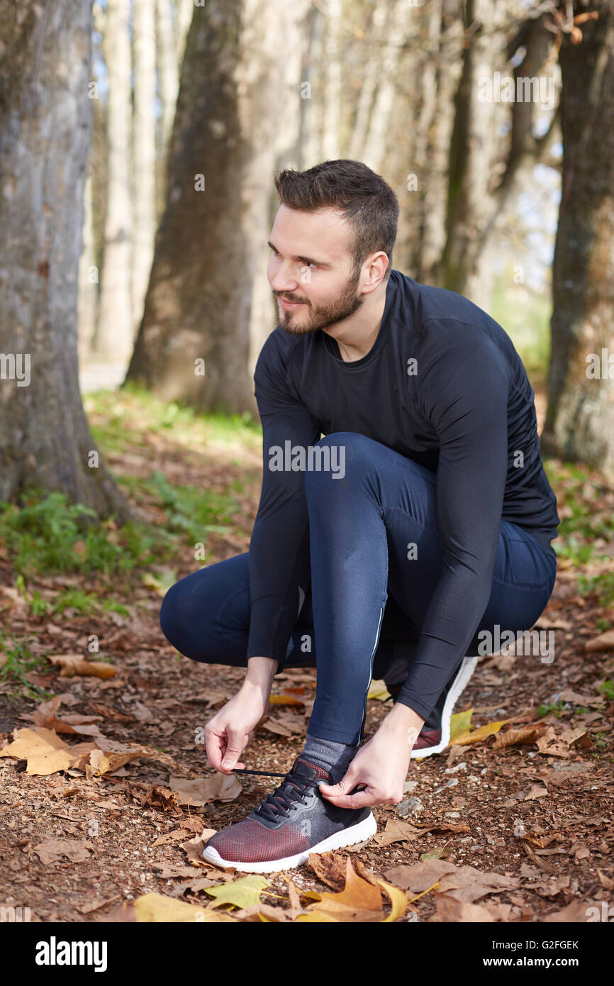Runner doing stretching outside in autumn Stock Photo - Alamy